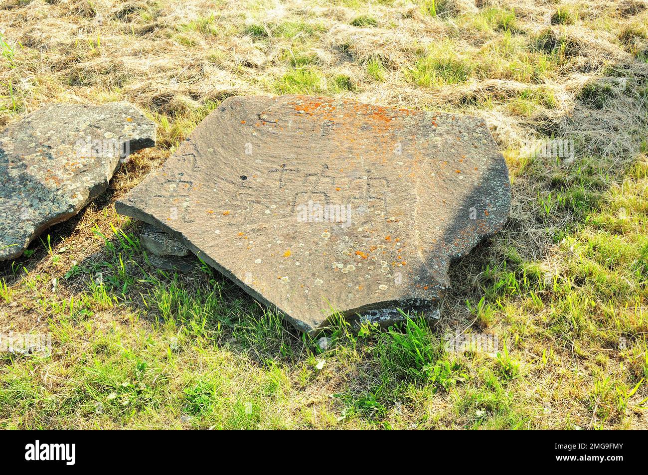 A large flat stone with ancient cave paintings depicting human figures ...