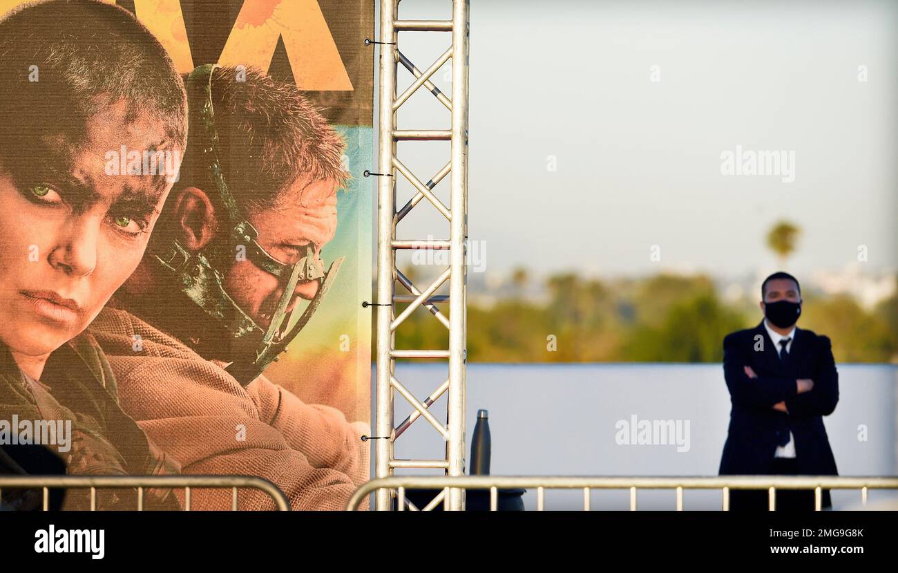A masked security guard stands alongside a poster for the film "Mad Max ...