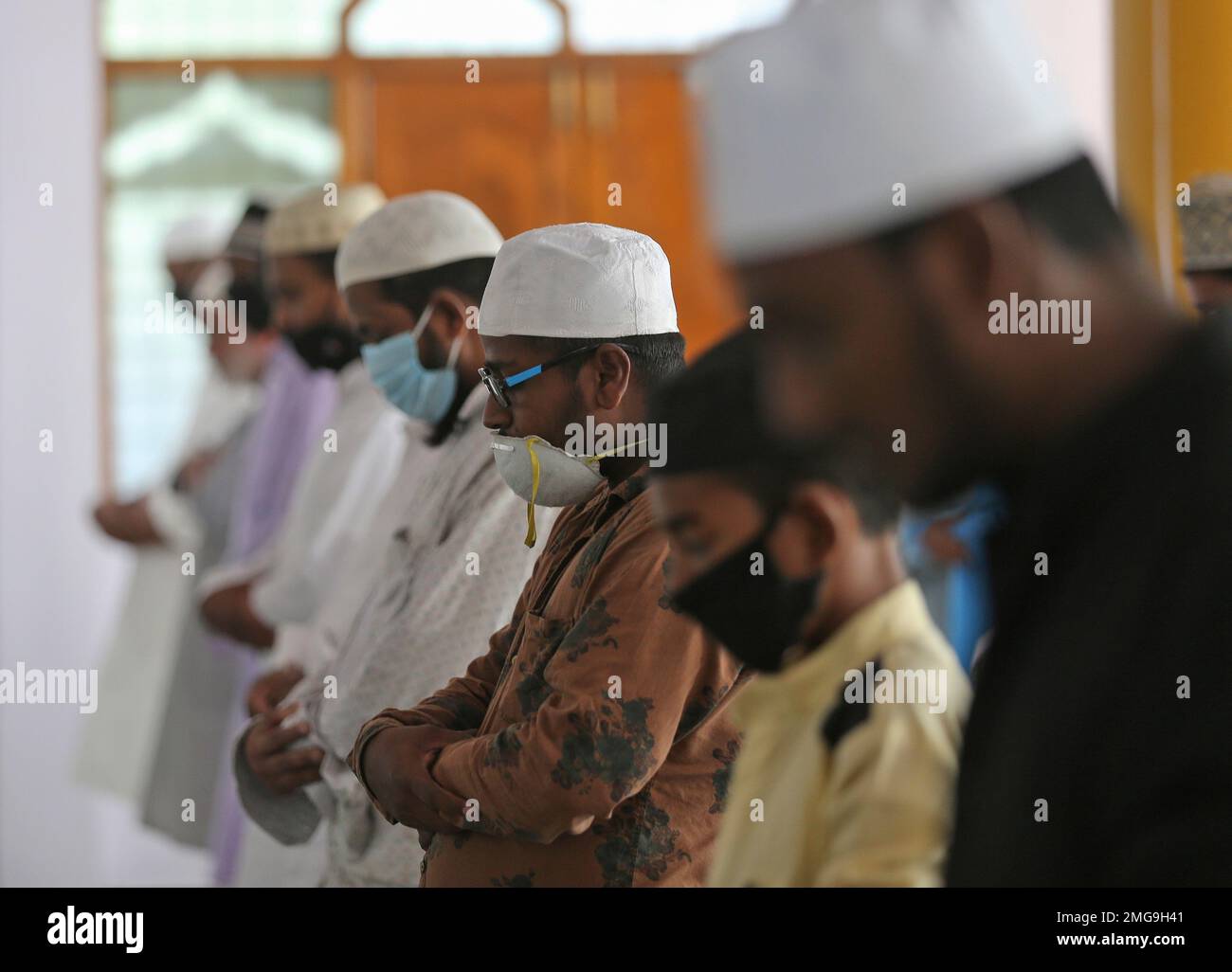 Indian Muslims wearing face masks and maintaining social distance offer ...