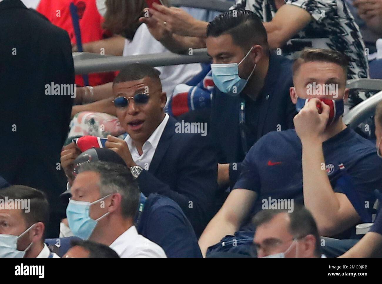 PSG's Kylian Mbappe, left, who is injured, wears a mask to protect from ...
