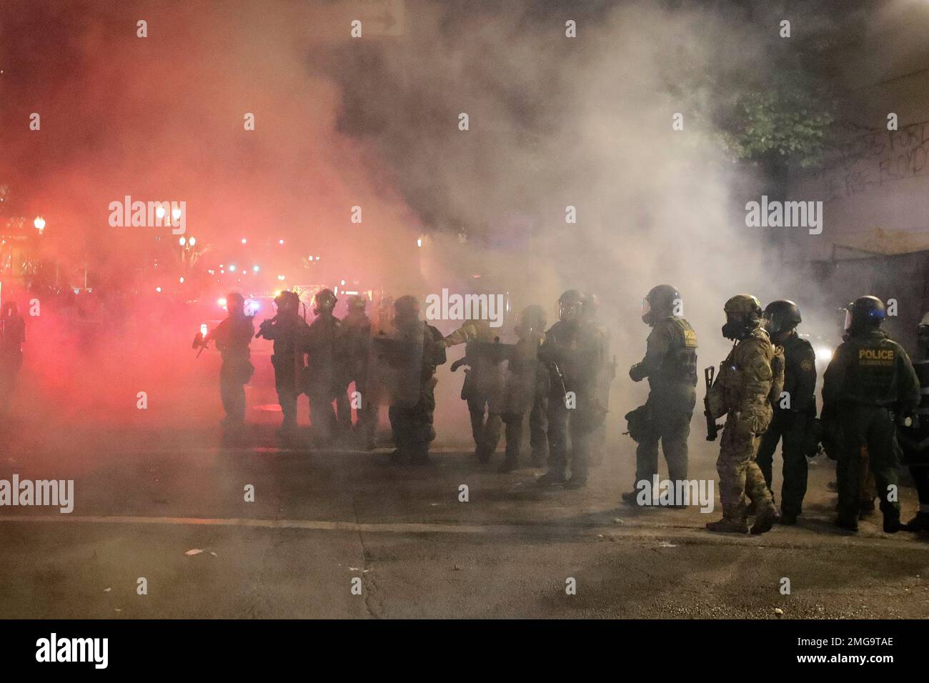 Federal officers walk in formation after a crowd threw fireworks during ...