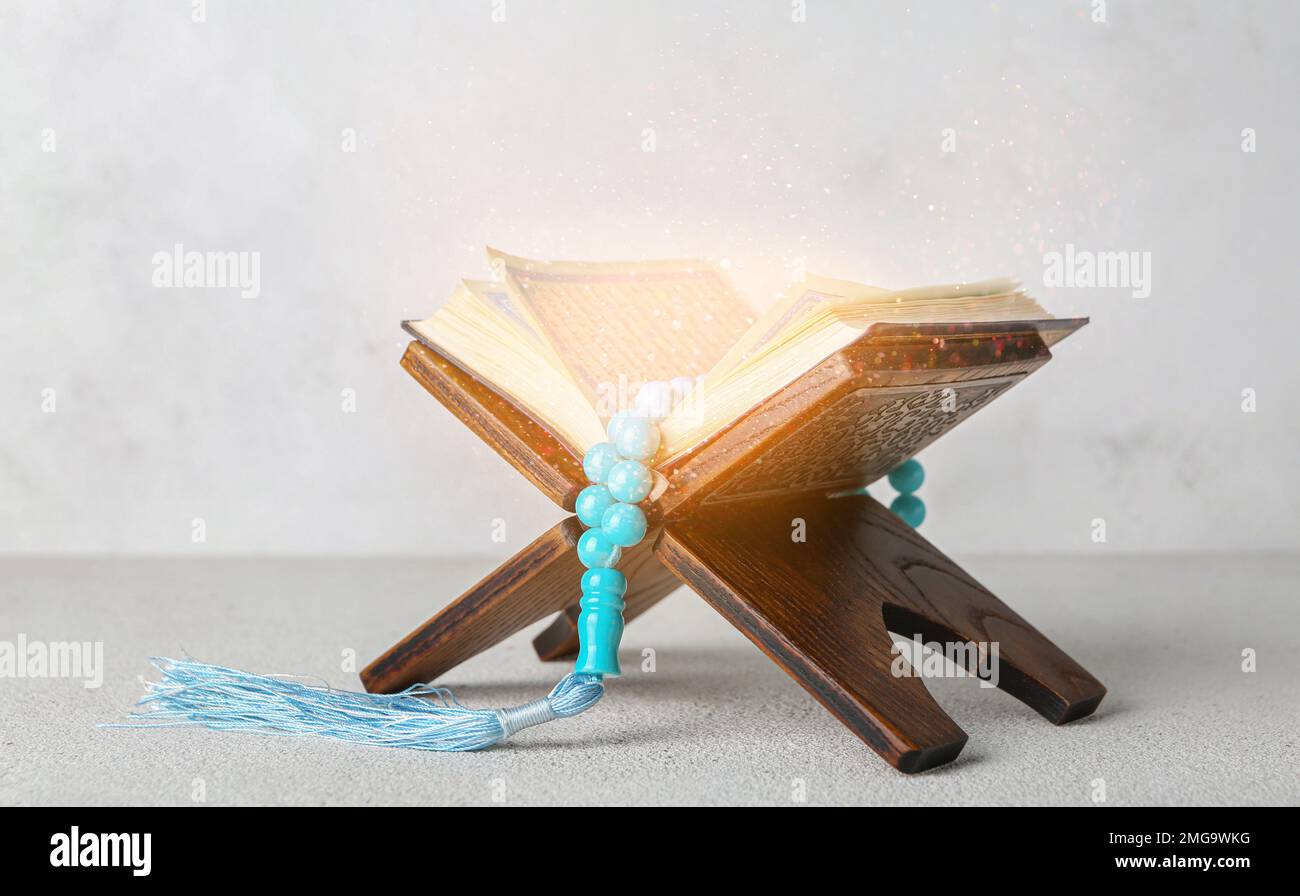 Muslim tasbih and Quran book on light background Stock Photo - Alamy