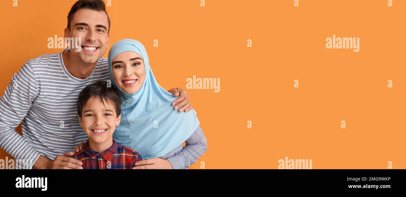 Portrait of happy Muslim family on orange background with space for ...