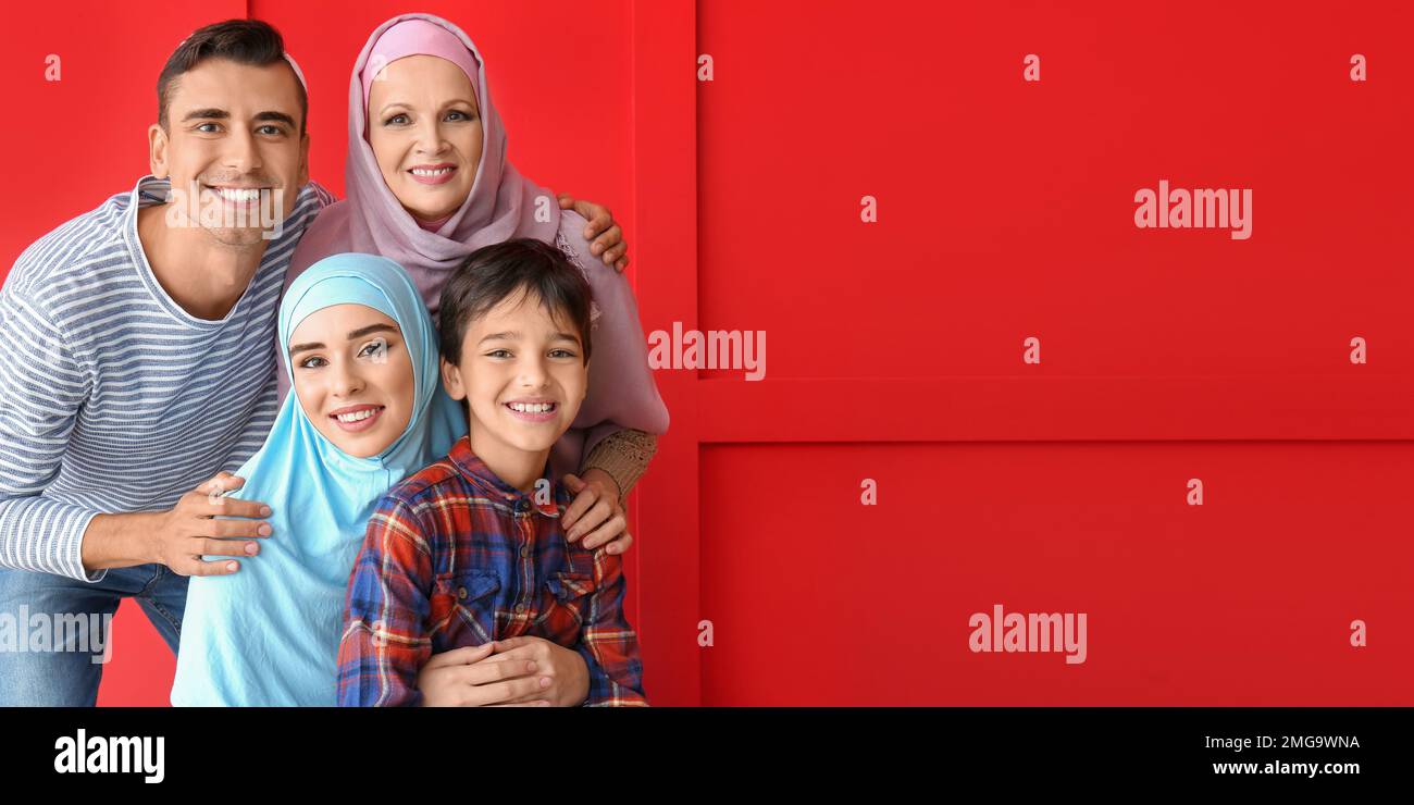 Portrait of happy Muslim family on red background with space for text ...