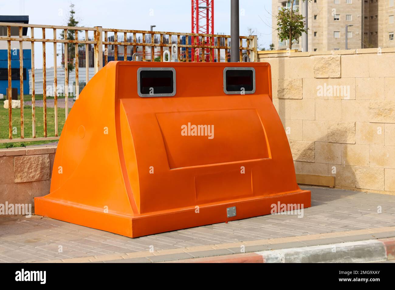 Orange garbage container on city street Stock Photo - Alamy