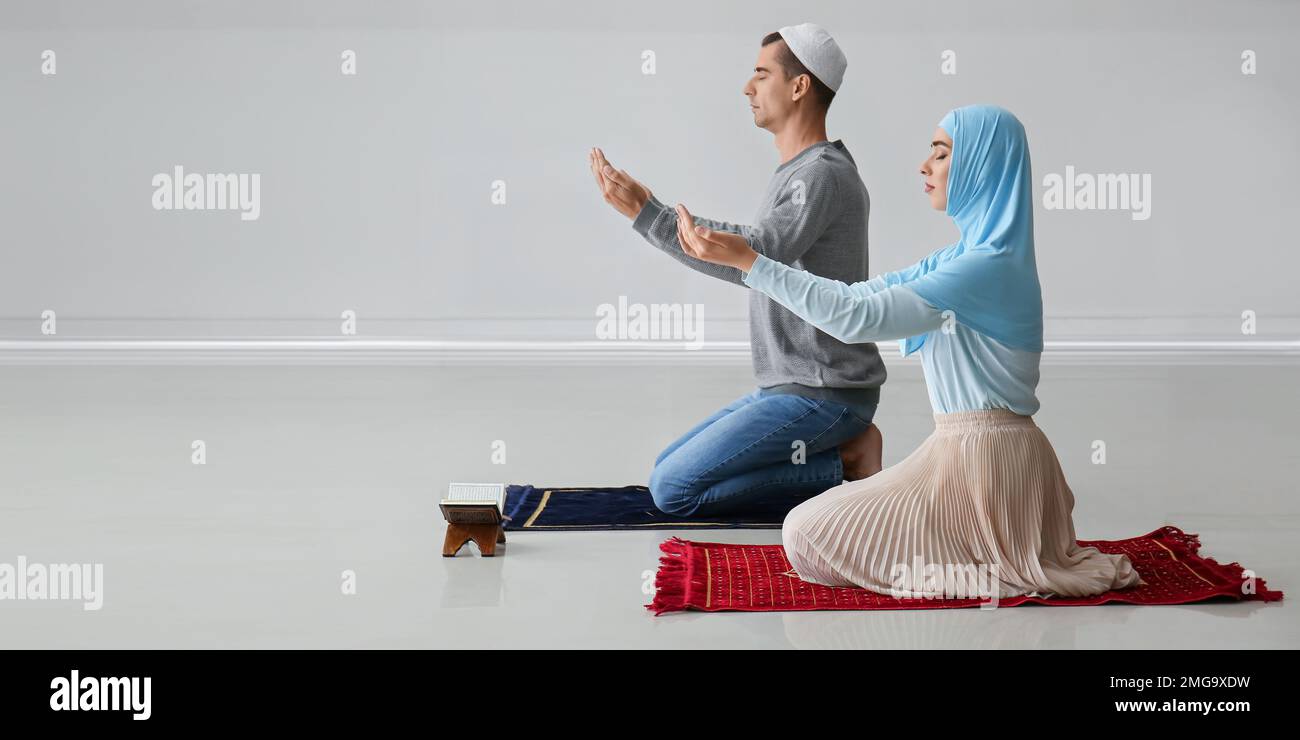 Muslim couple praying in light room Stock Photo - Alamy