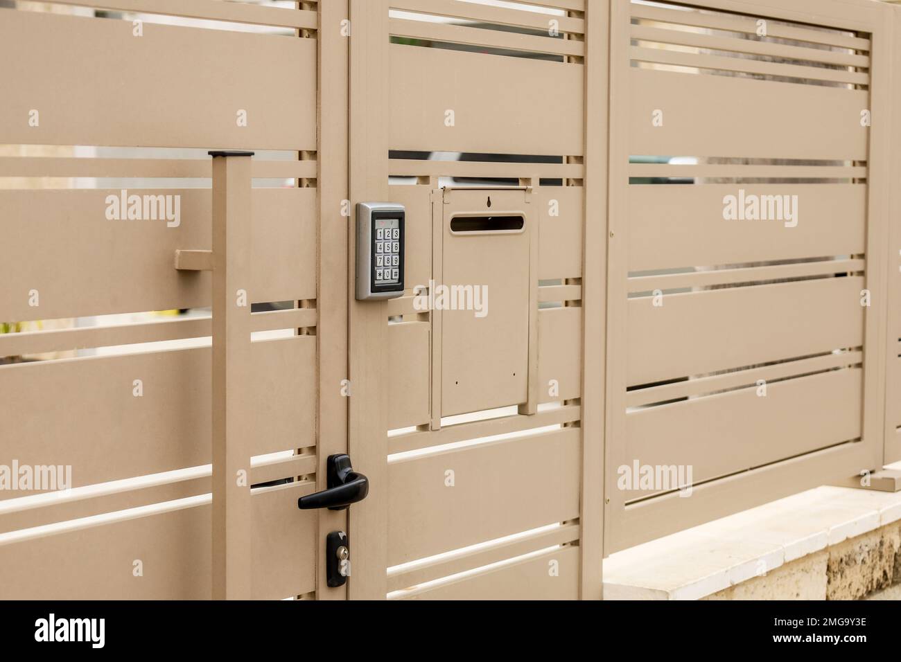 Modern fence with door and intercom outdoors Stock Photo - Alamy