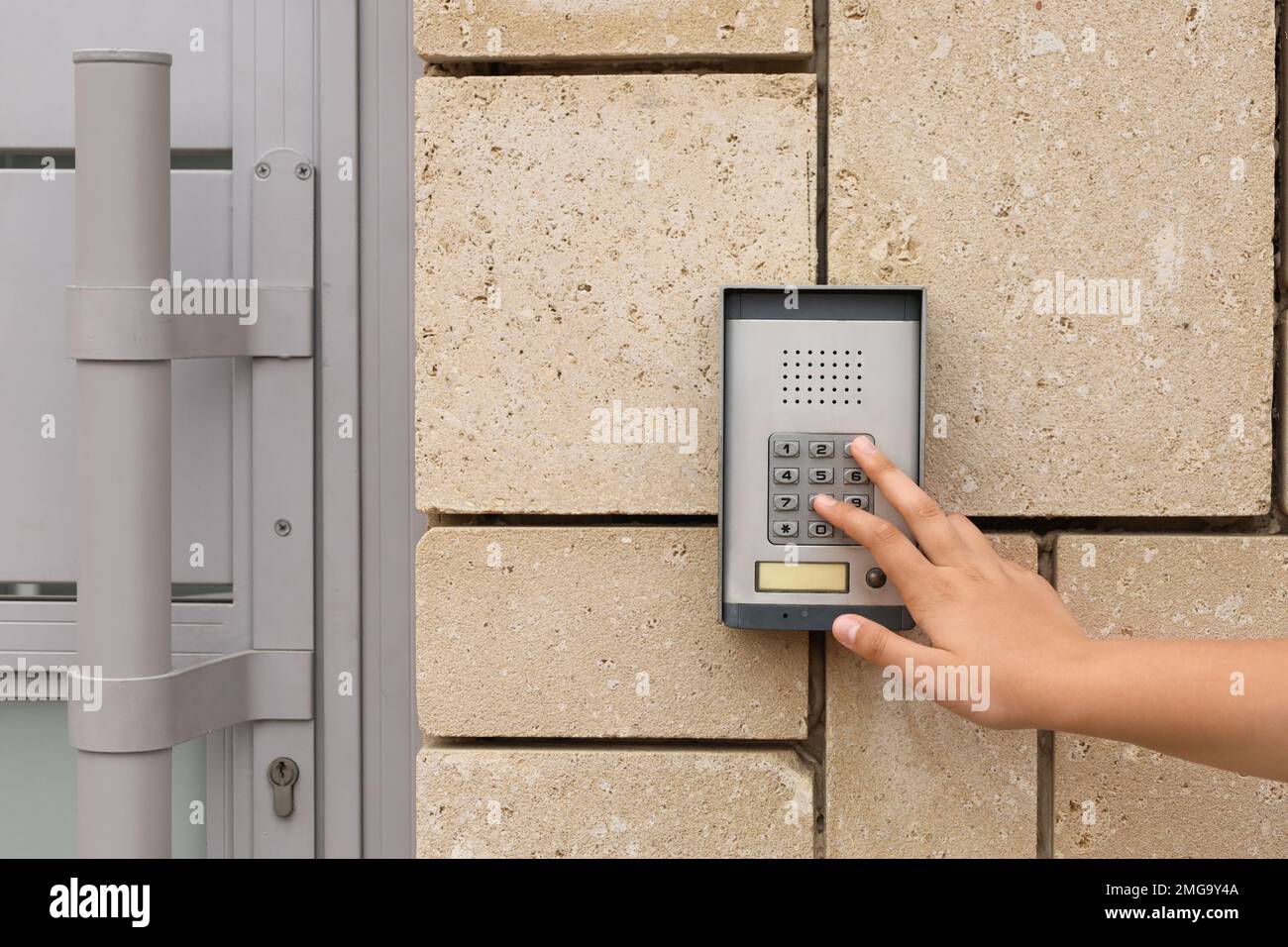 Child using modern intercom on stone wall outdoors, closeup Stock Photo ...