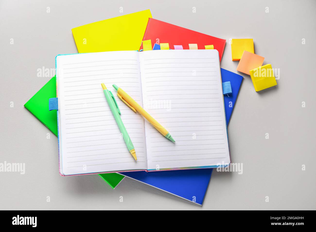Different notebooks, sticky notes and pens on light background Stock ...