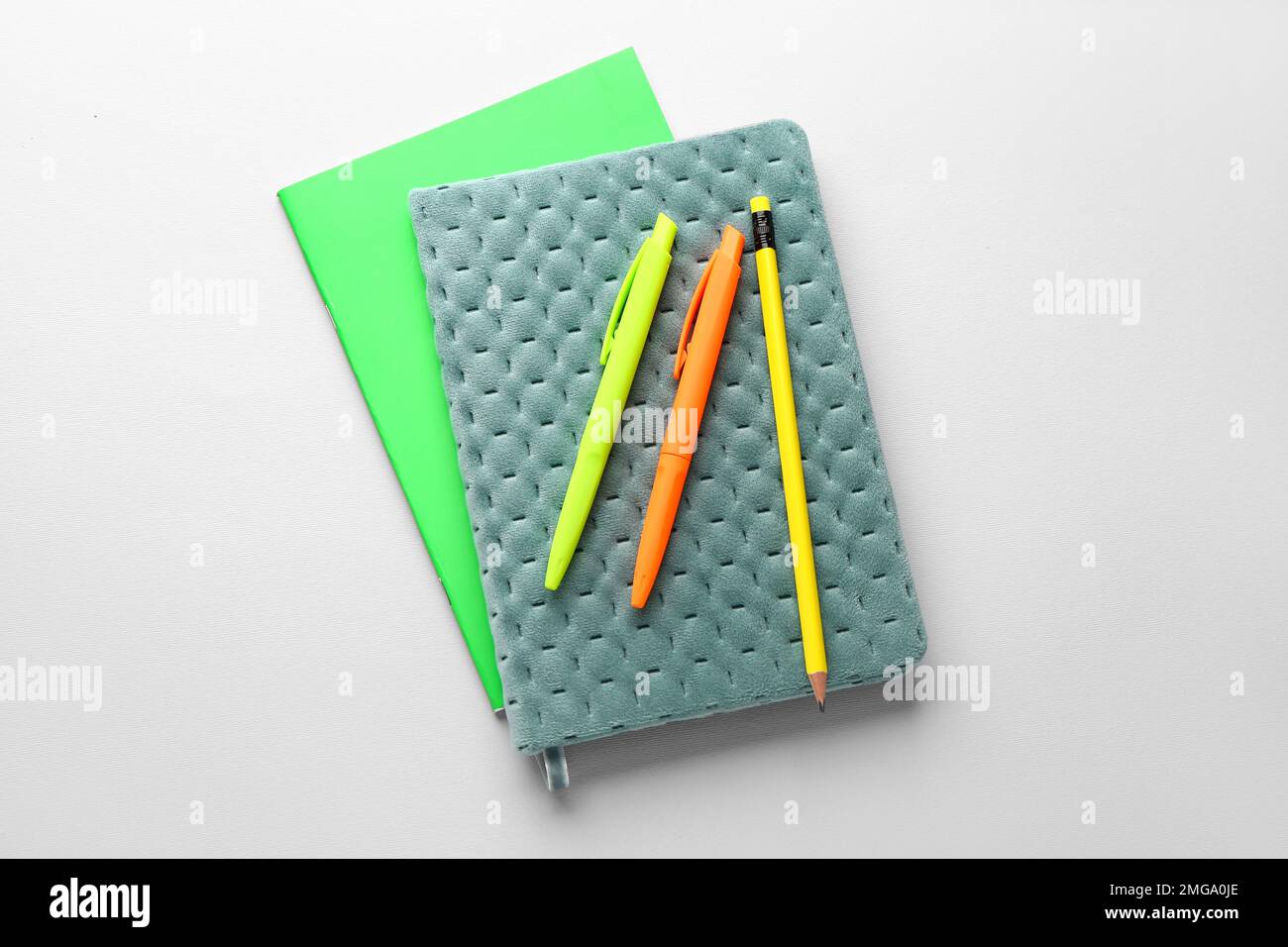 Notebooks, pens and pencil on light background Stock Photo - Alamy