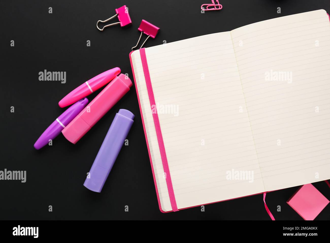 Blank open notebook, markers and binder clips on dark background Stock ...