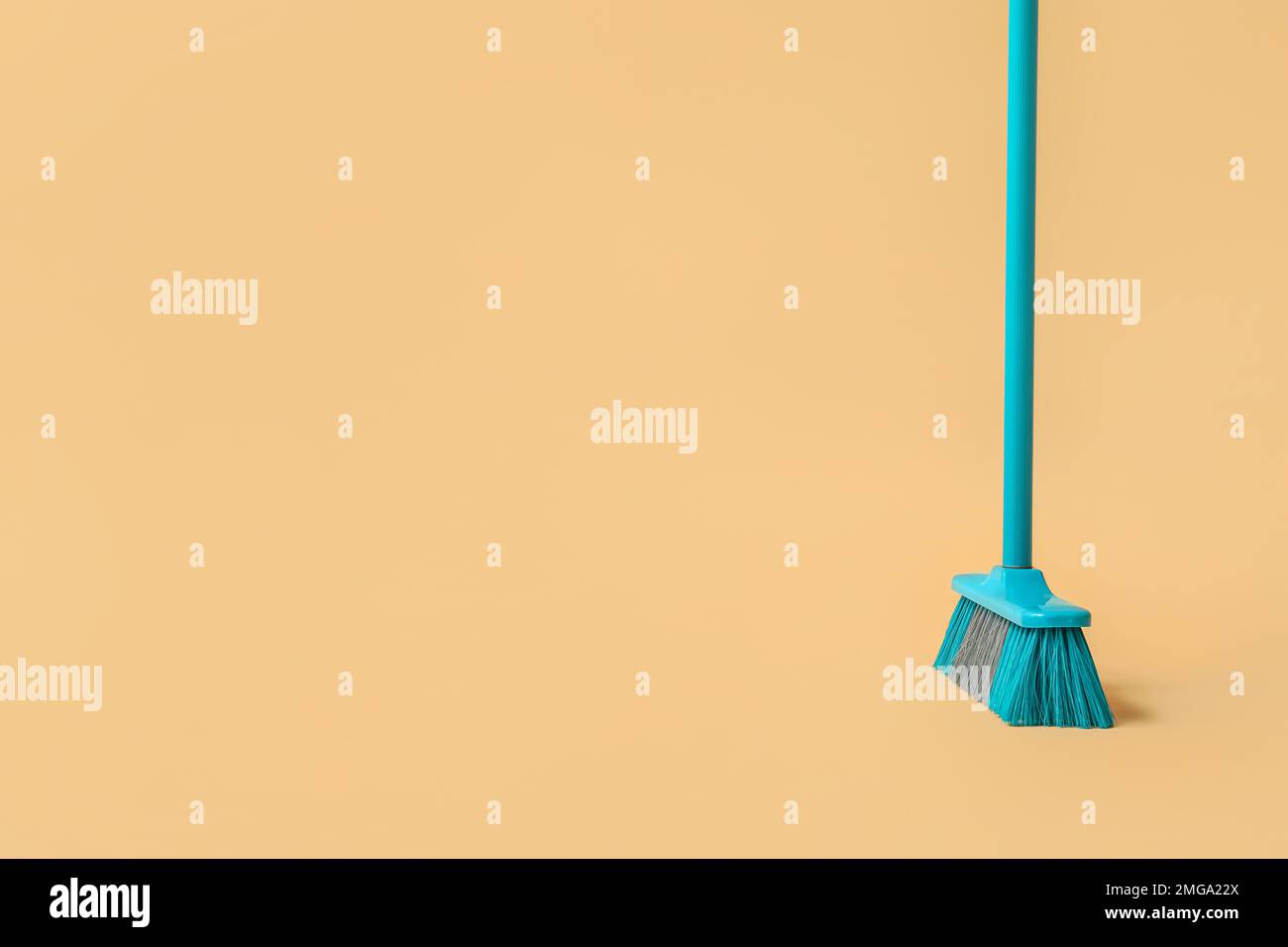 Blue cleaning broom on orange background Stock Photo - Alamy