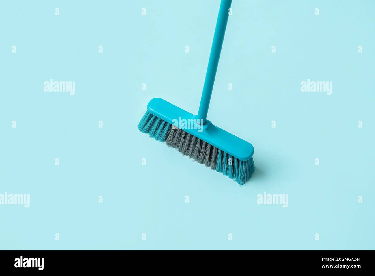 Blue plastic broom on color background Stock Photo - Alamy