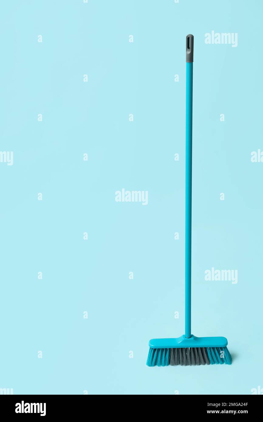 Blue plastic broom on color background Stock Photo - Alamy