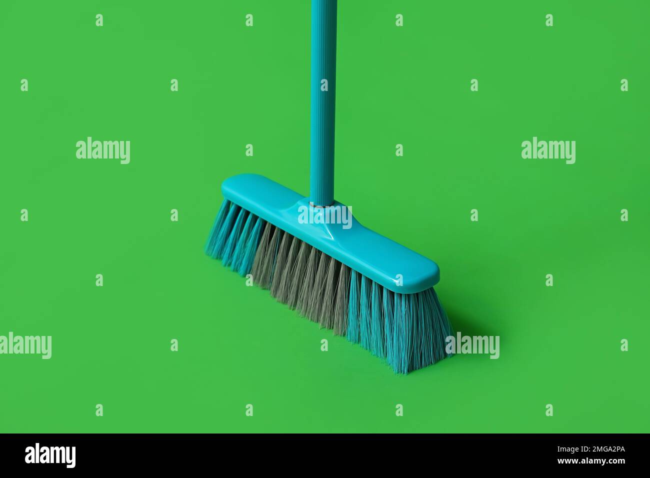 Plastic cleaning broom on green background Stock Photo - Alamy