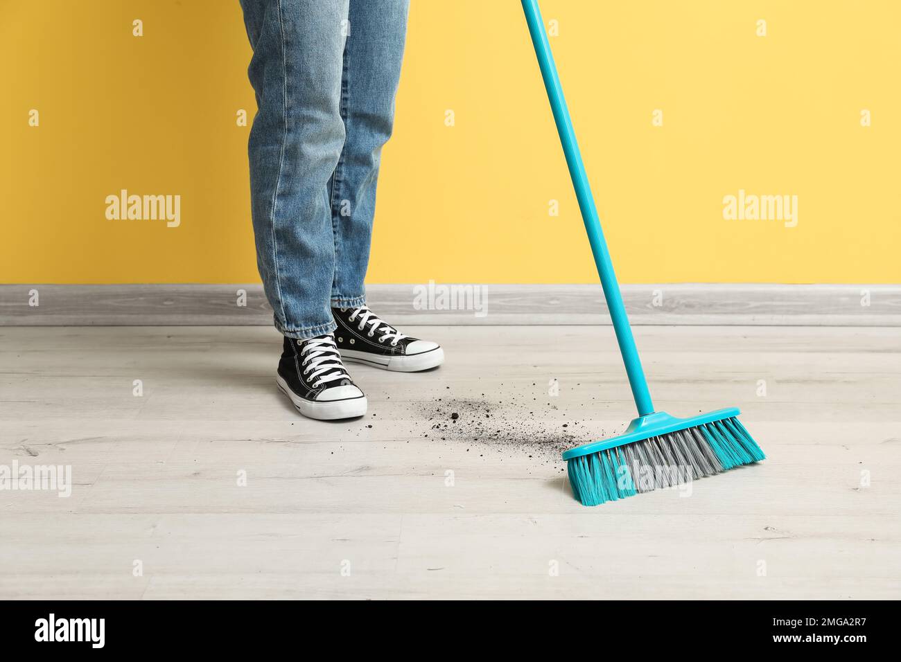 Woman sweeping floor with broom Stock Photo - Alamy