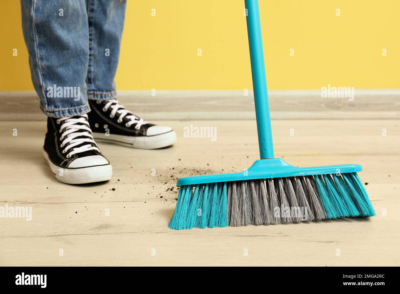 Woman sweeping floor with broom Stock Photo - Alamy