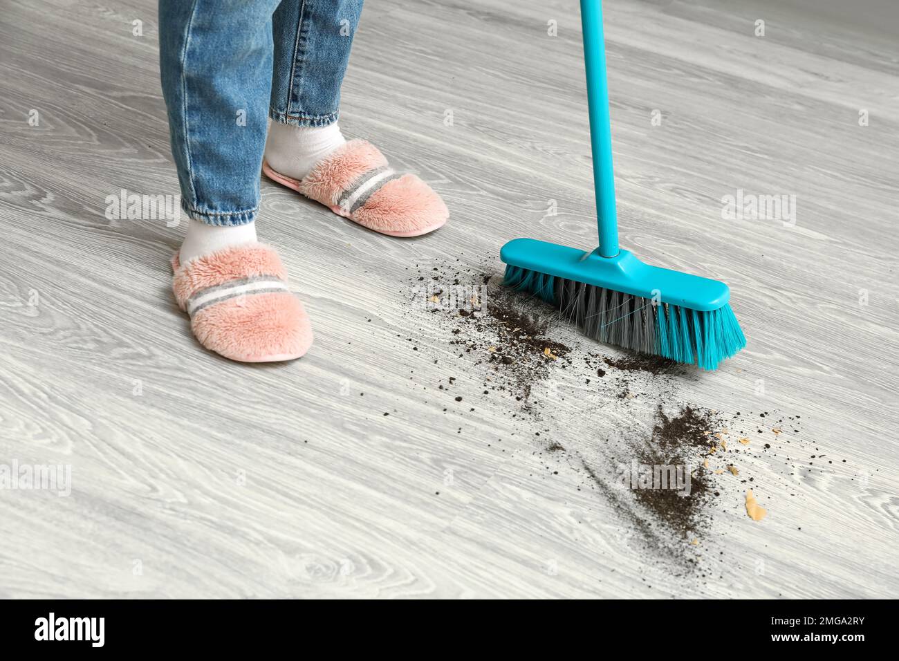 Woman sweeping floor with broom Stock Photo - Alamy