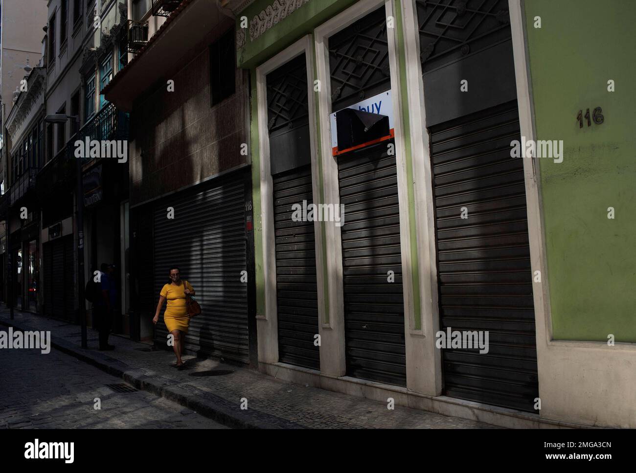 A woman walks past shuttered storefronts amid the new coronavirus ...
