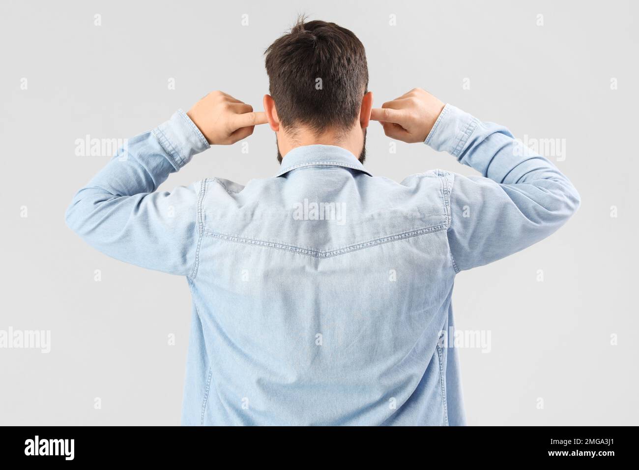 Young man suffering from loud noise on grey background, back view Stock ...