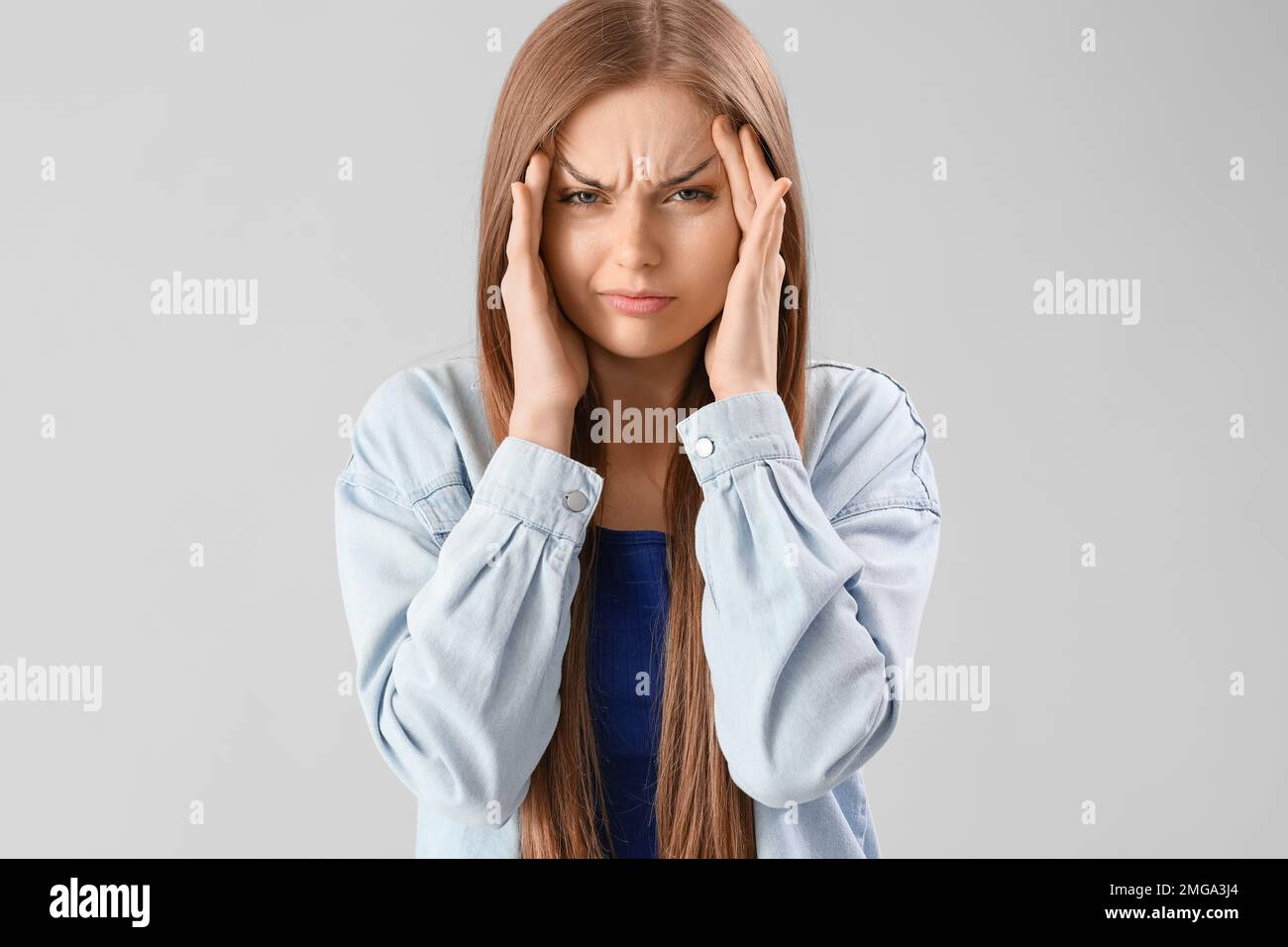 Young woman suffering from loud noise on grey background Stock Photo ...