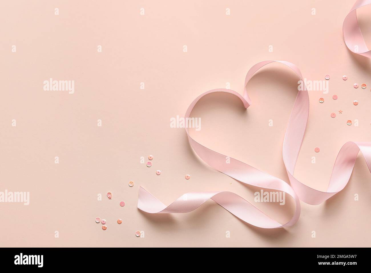 Pink ribbon with hearts on beige background. Valentine's Day ...