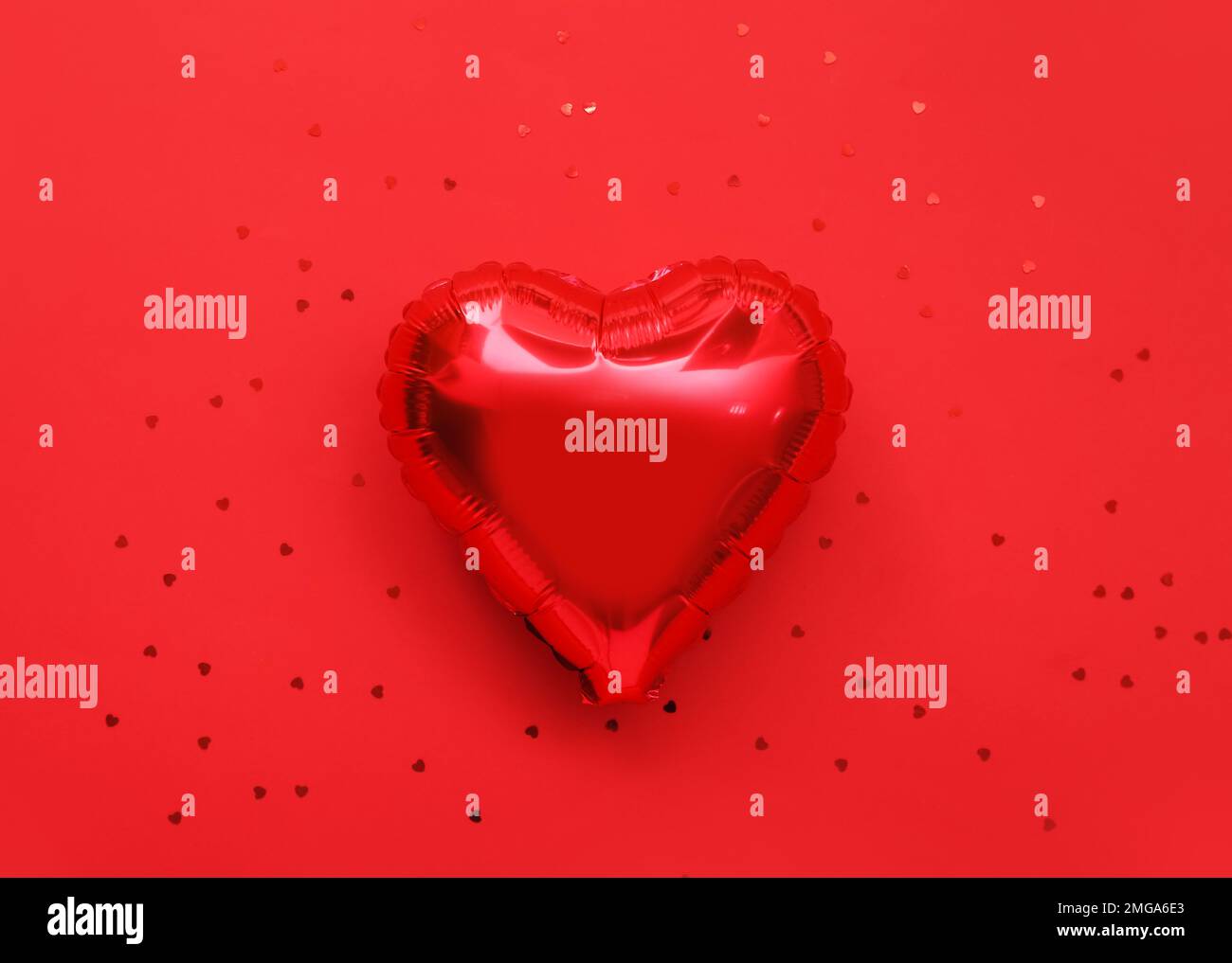 Heart shaped balloon and sequins on red background. Valentine's Day ...