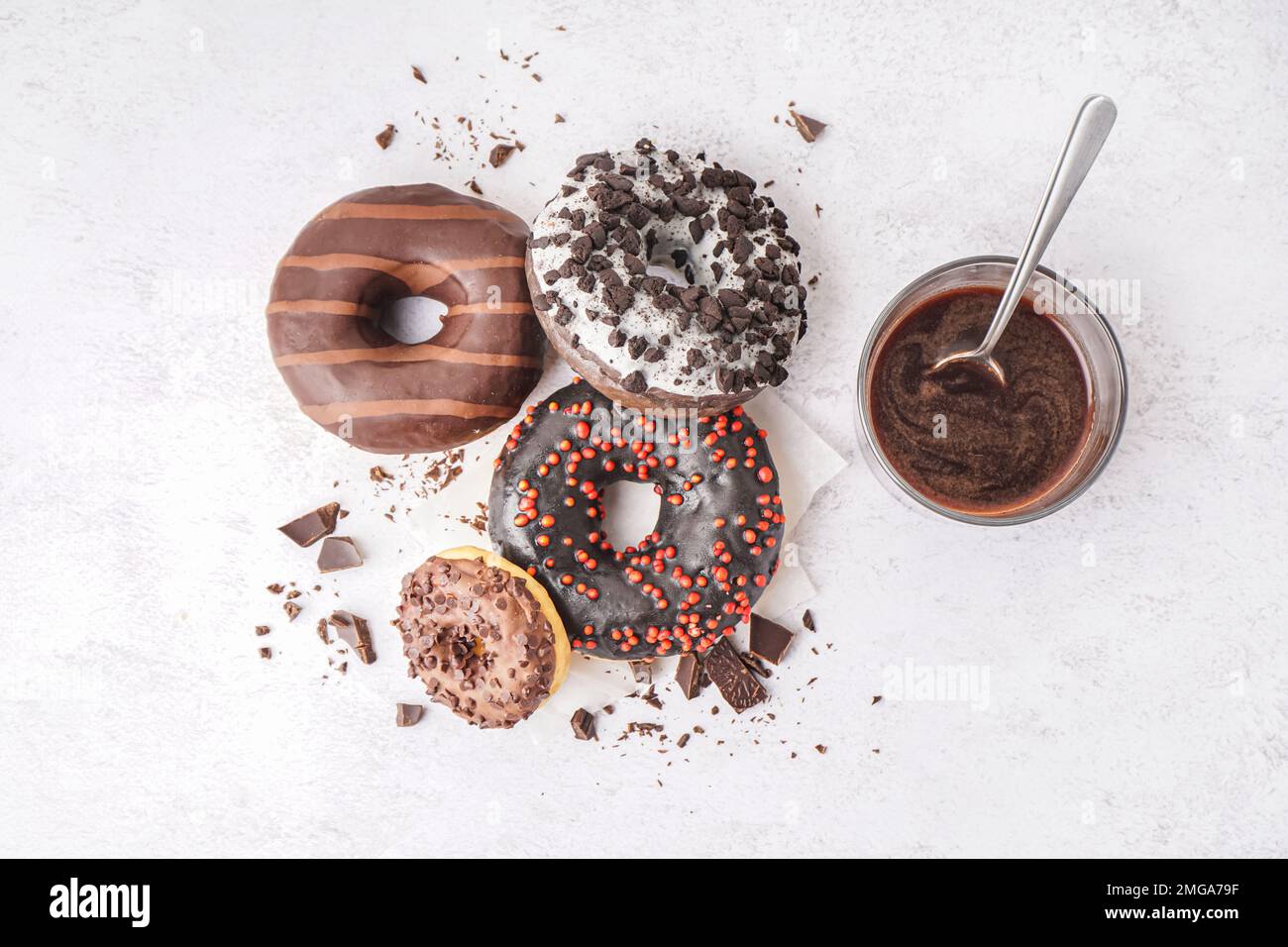 Delicious chocolate donuts and glass of chocolate pudding on white ...