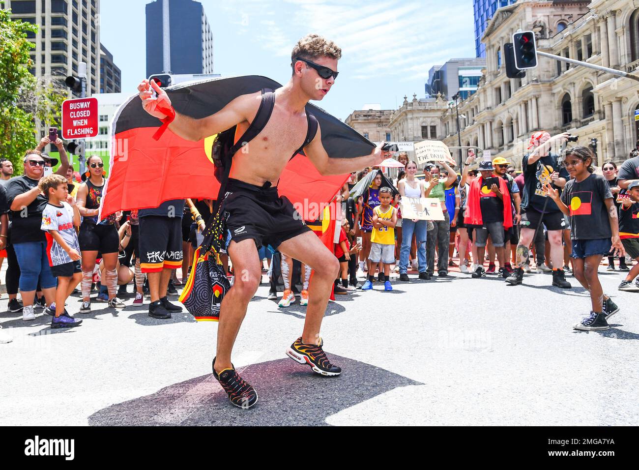 A man dances as people march during an Invasion Day rally in Brisbane ...