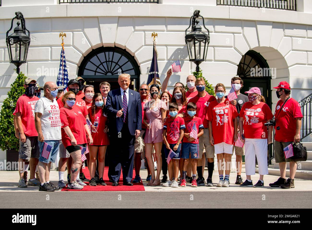 President Donald Trump poses for photographs with a group of supporters ...