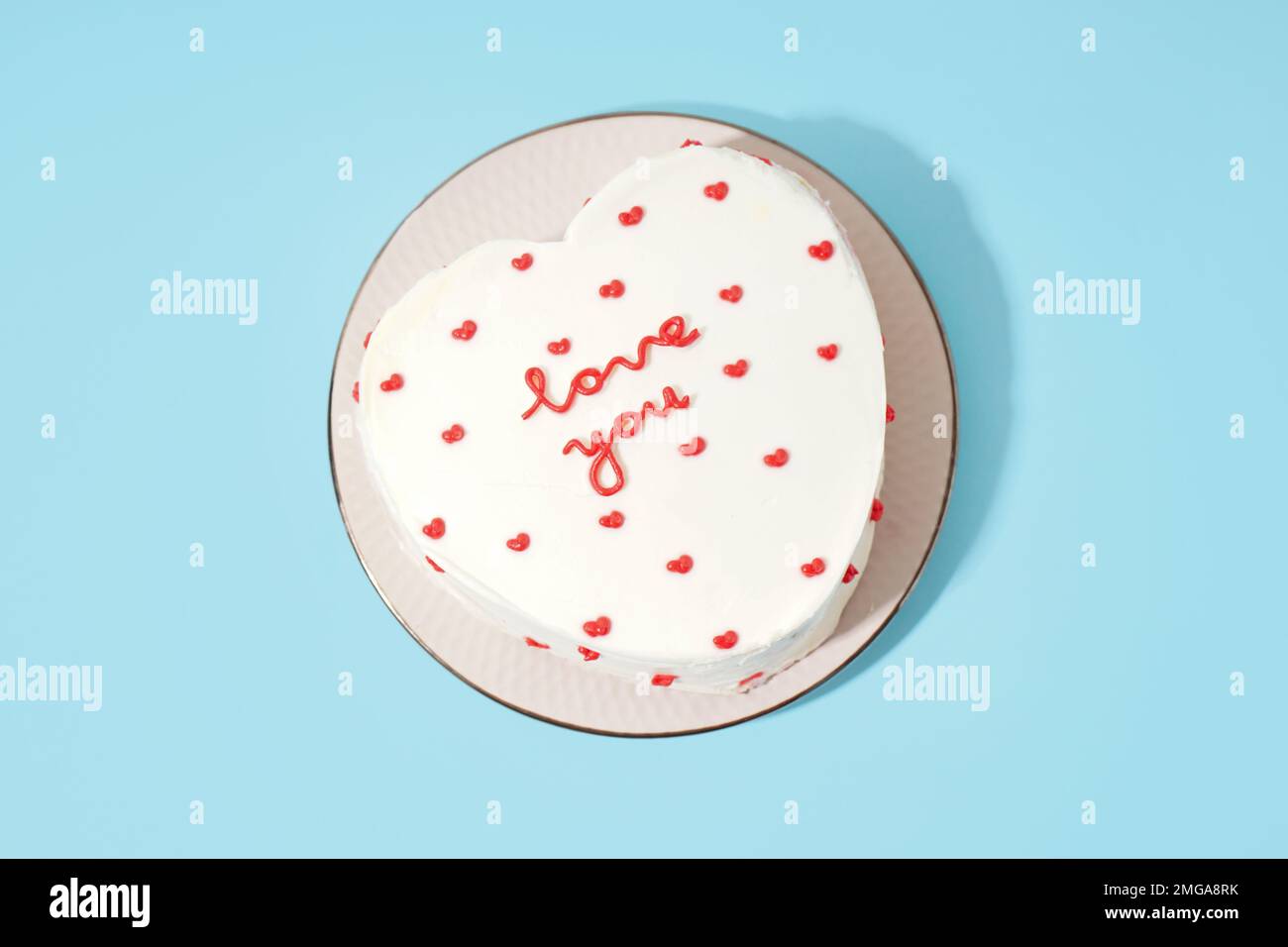 Plate with heart-shaped bento cake on blue background. Valentine's Day ...