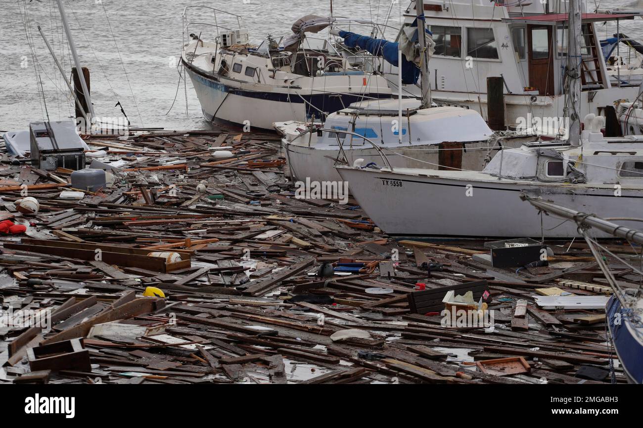Debris floats around damaged boats in a marina after it was hit by ...