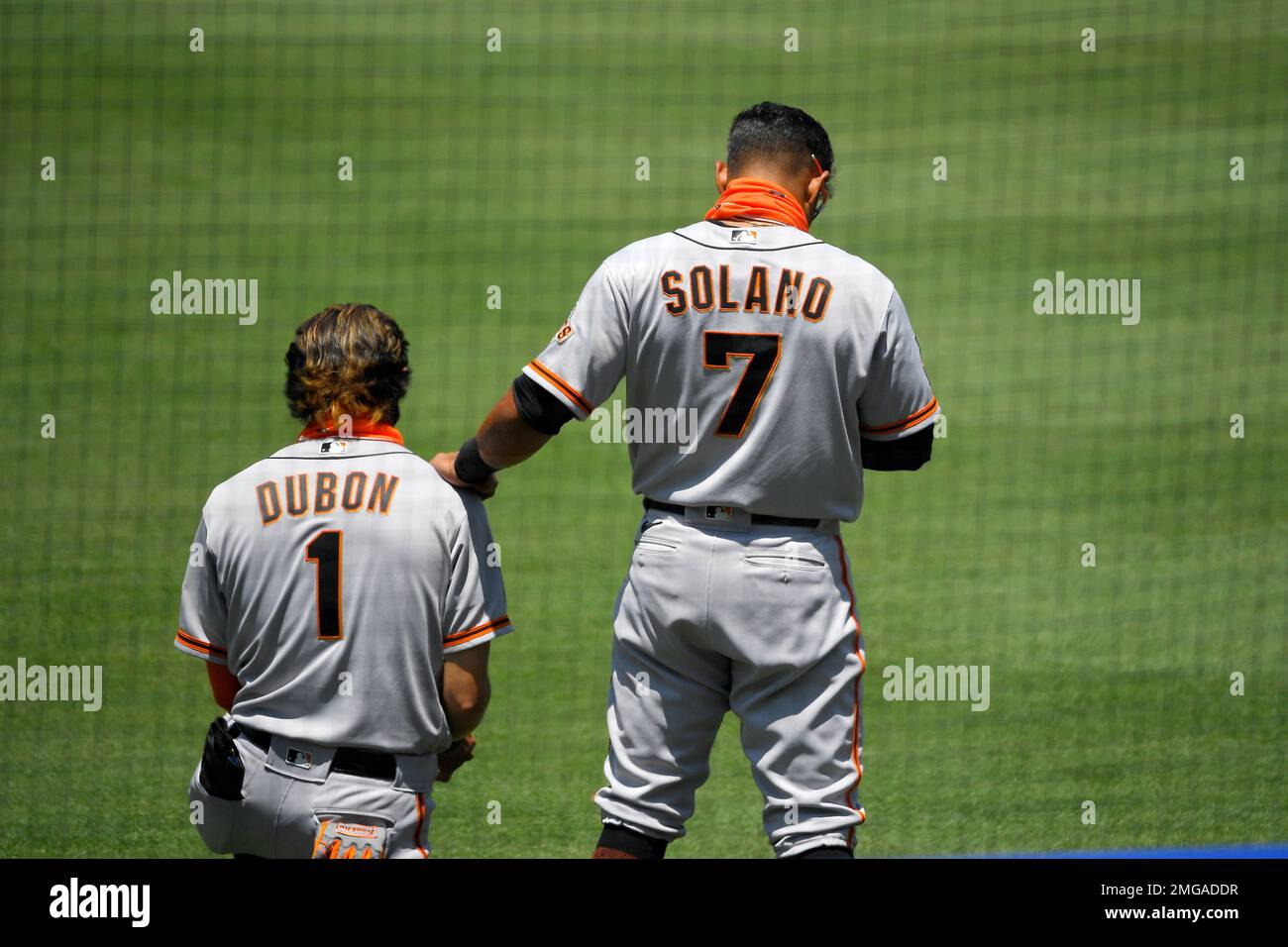 San Francisco Giants' Mauricio Dubon, left, kneels as Donovan Solano ...