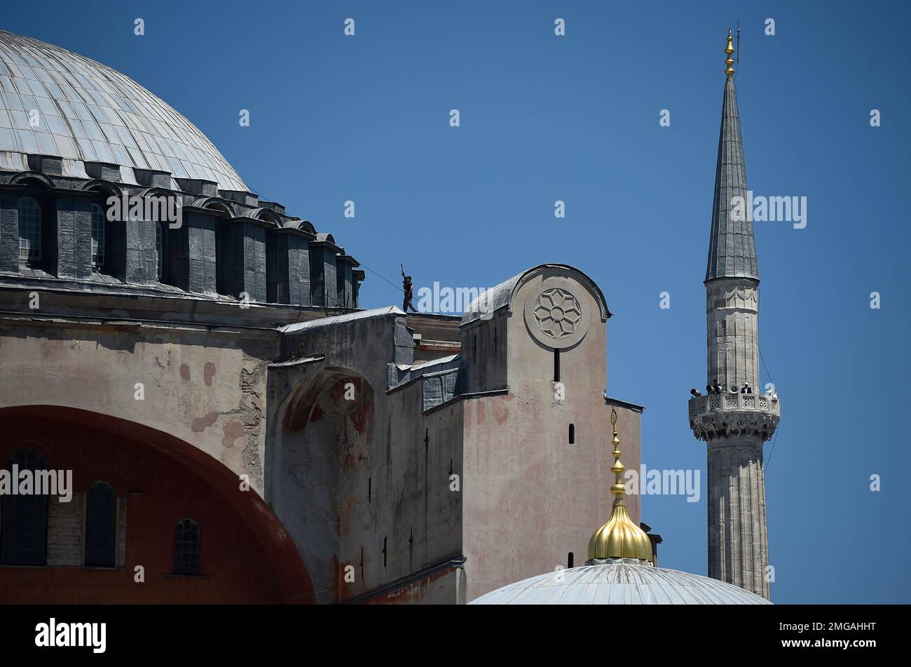 A Turkish police officer walk with his gin on the dome as a muezzin ...