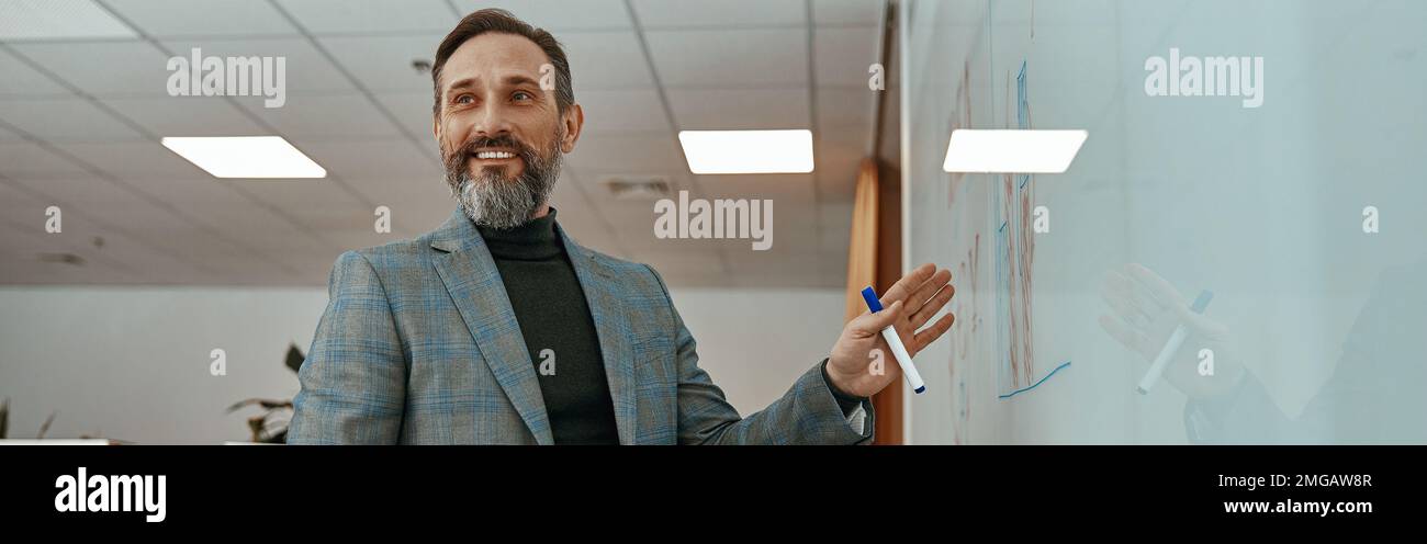 Smiling adult man using whiteboard for his presentation Stock Photo - Alamy