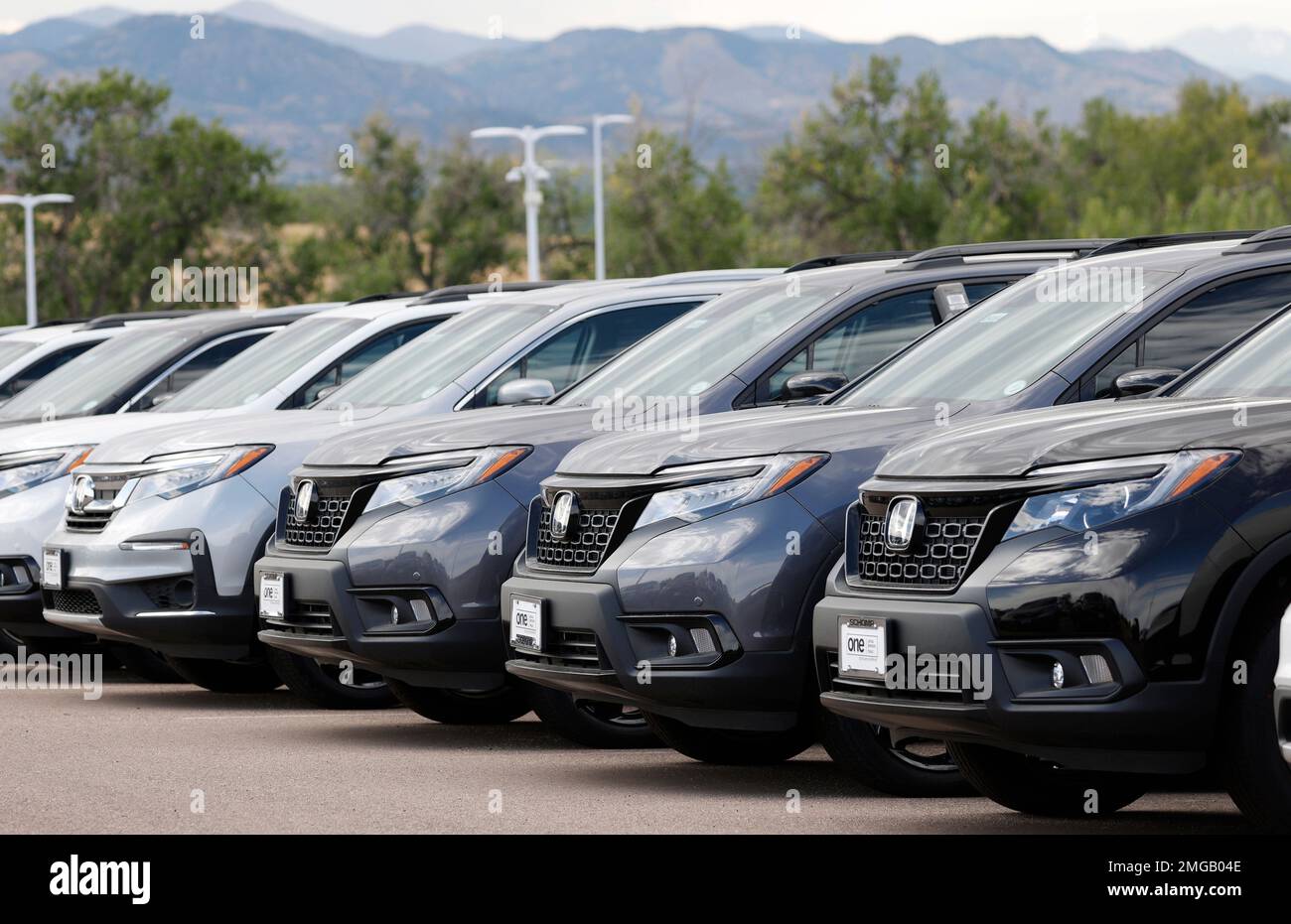 A long row of unsold 2020 Pilot sports-utility vehicles sits at a Honda ...