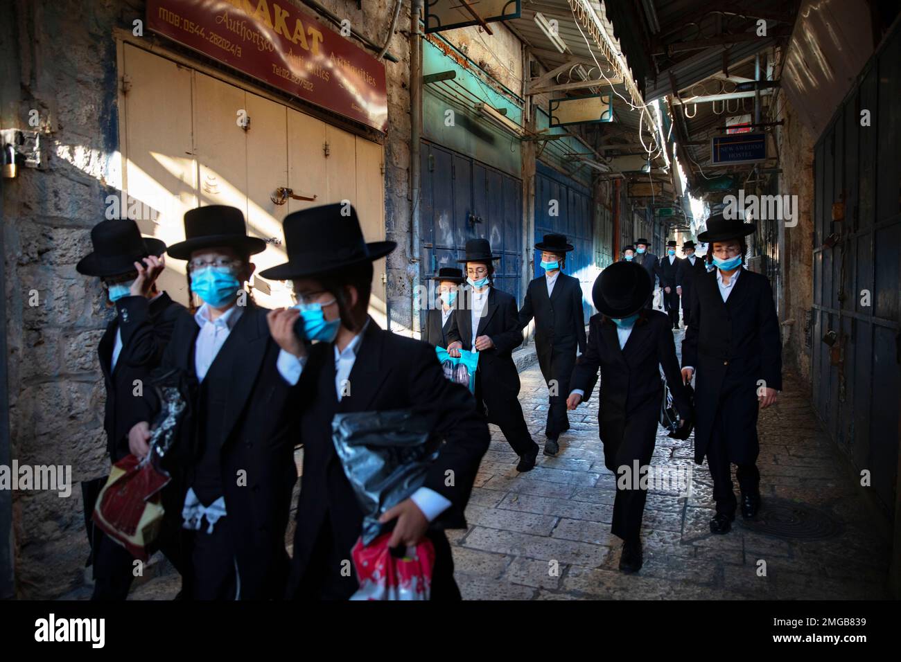 A group of ultra-Orthodox Jewish youth wear protective face masks ...