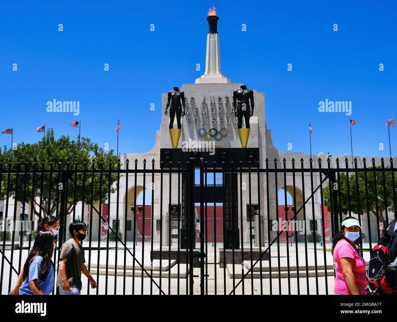 People walk past the front of the Los Angeles Memorial Coliseum as the ...