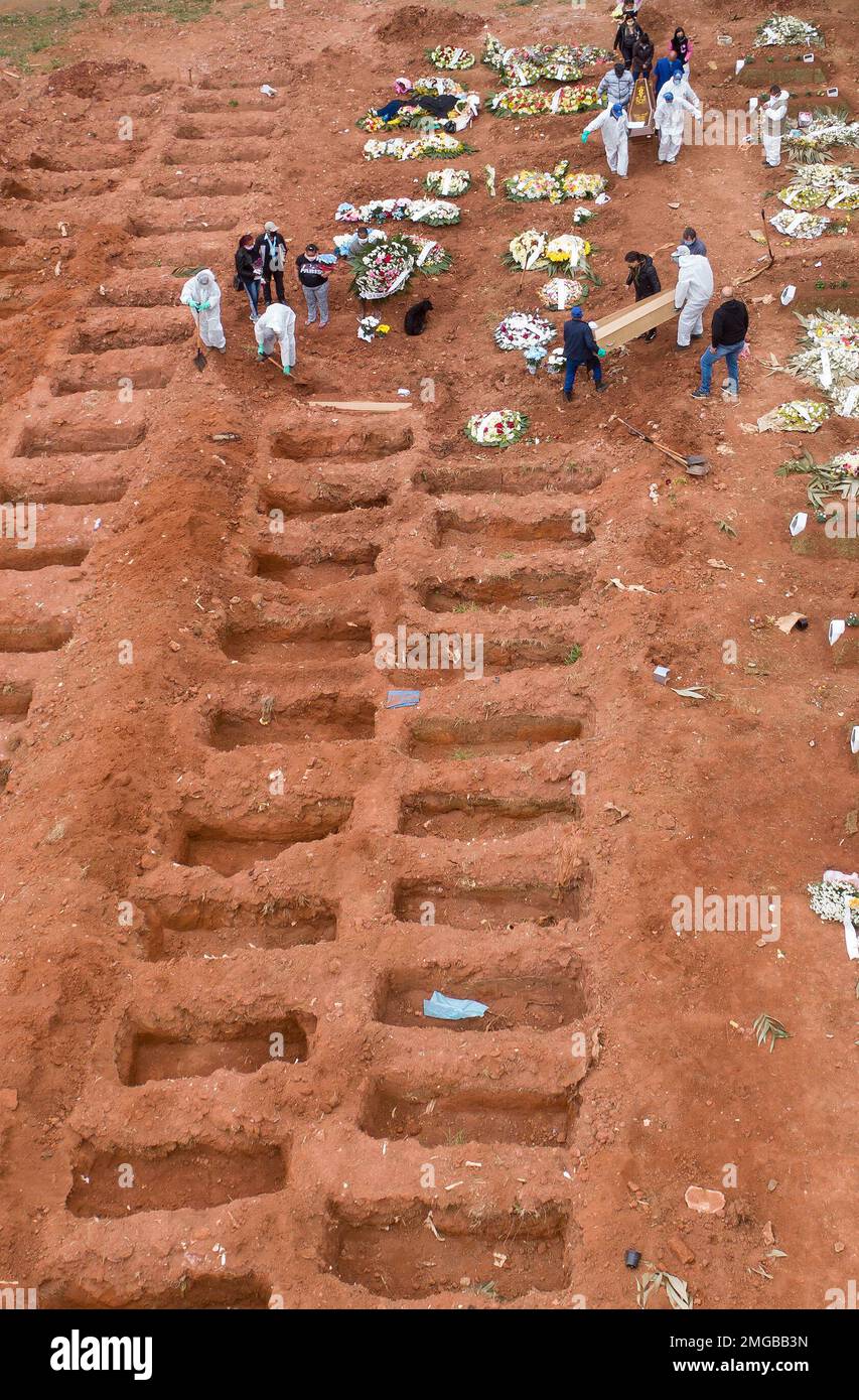 Cemetery workers in protective clothing bury victims of the new ...