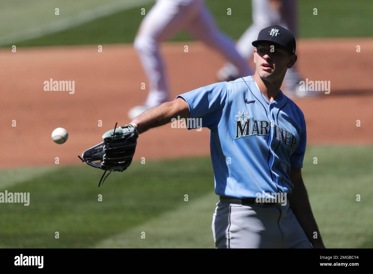 Seattle Mariners pitcher Nick Margevicius reaches for a ball during an ...
