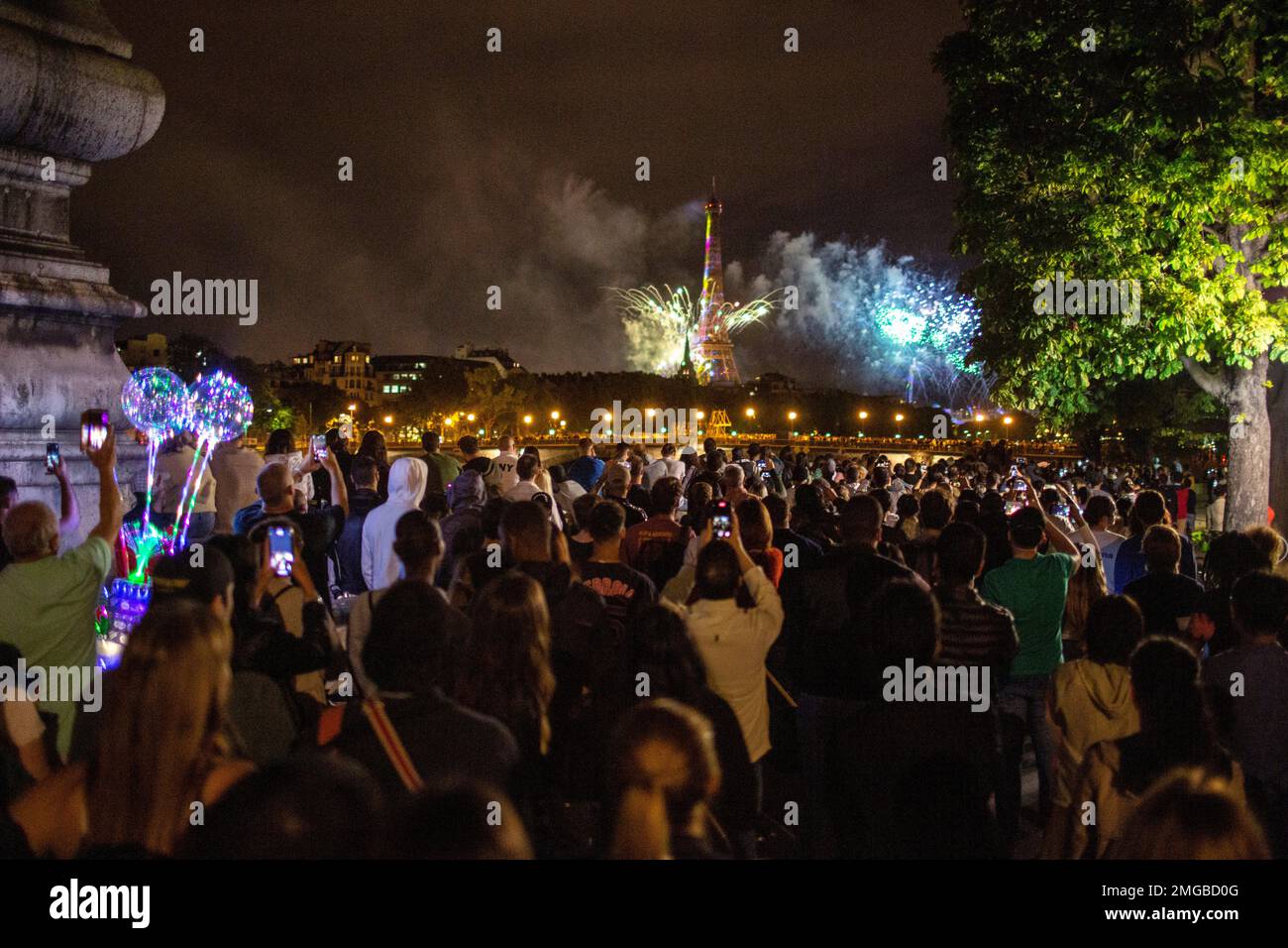 People attend the fireworks display by the Eiffel Tower in Paris during ...