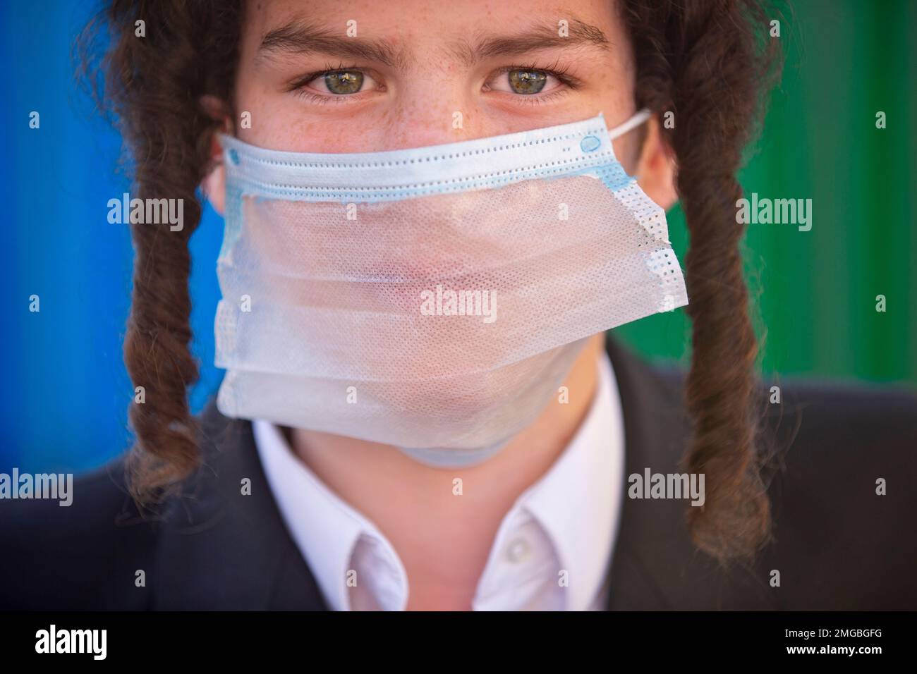 An Ultra-Orthodox Jewish youth wears a protective face mask amid ...
