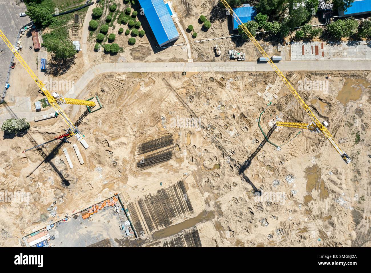 aerial view of the site prepared for construction with cranes and ...