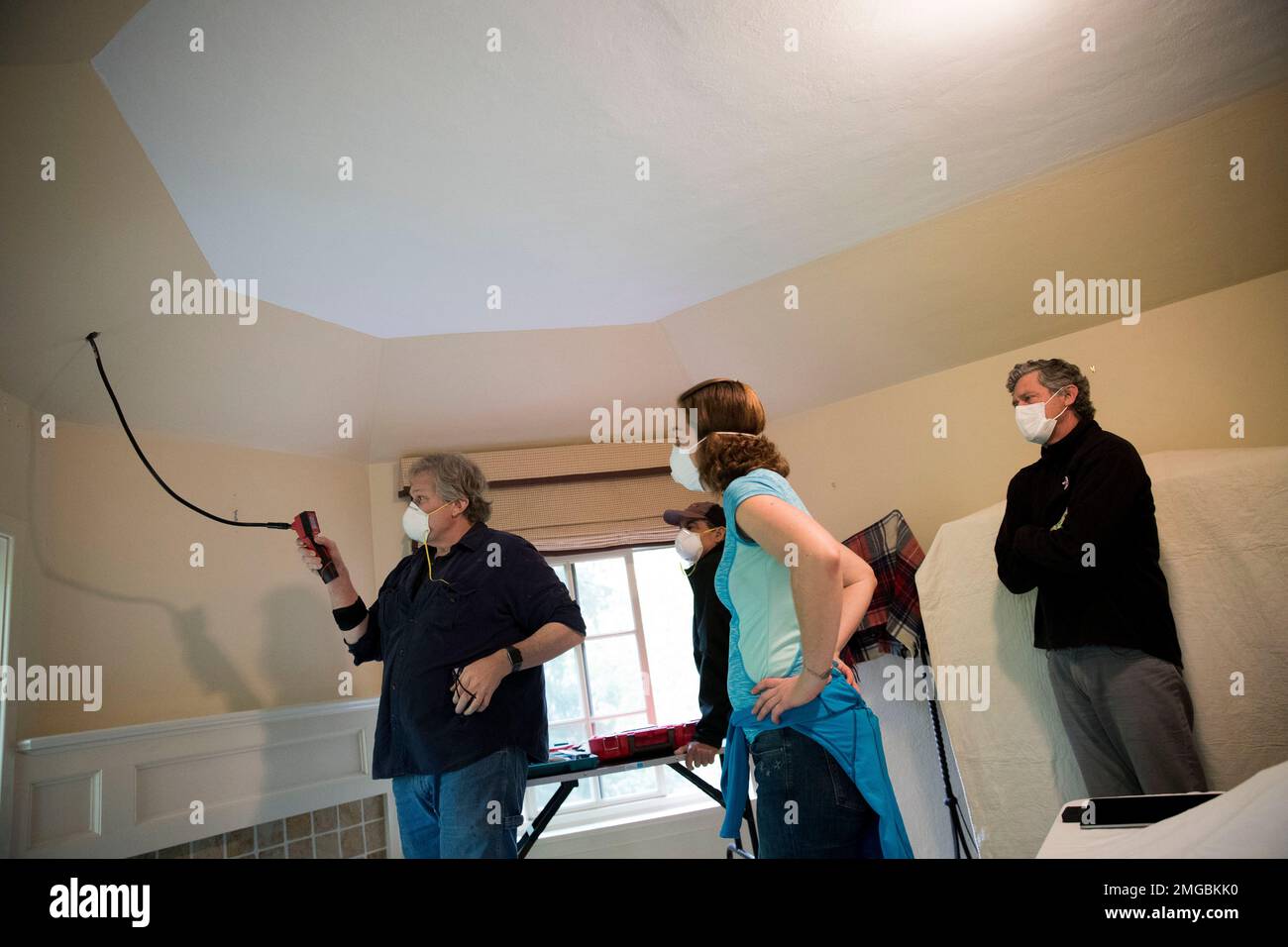 Homeowner Tom Patton, right, watches as beekeepers Sean Kennedy, left ...