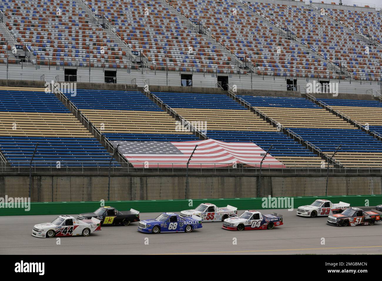 Drivers run past an empty grandstand during a NASCAR Truck Series race ...