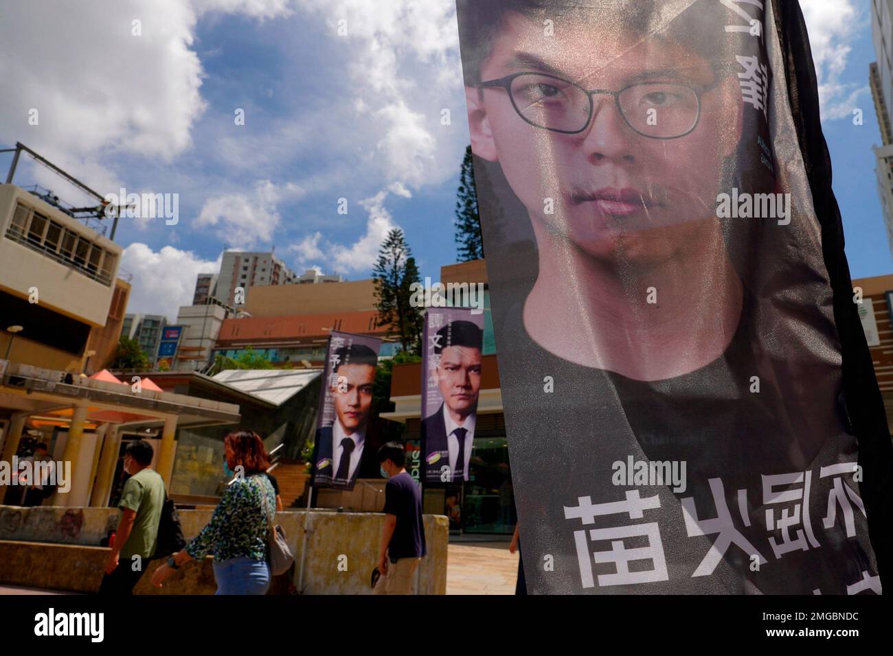 A banner of pro-democracy candidate Joshua Wong, right, is displayed ...