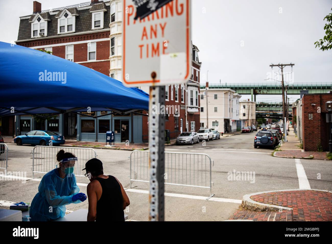 A medical worker instructs a man how to swab his nose at a free COVID ...