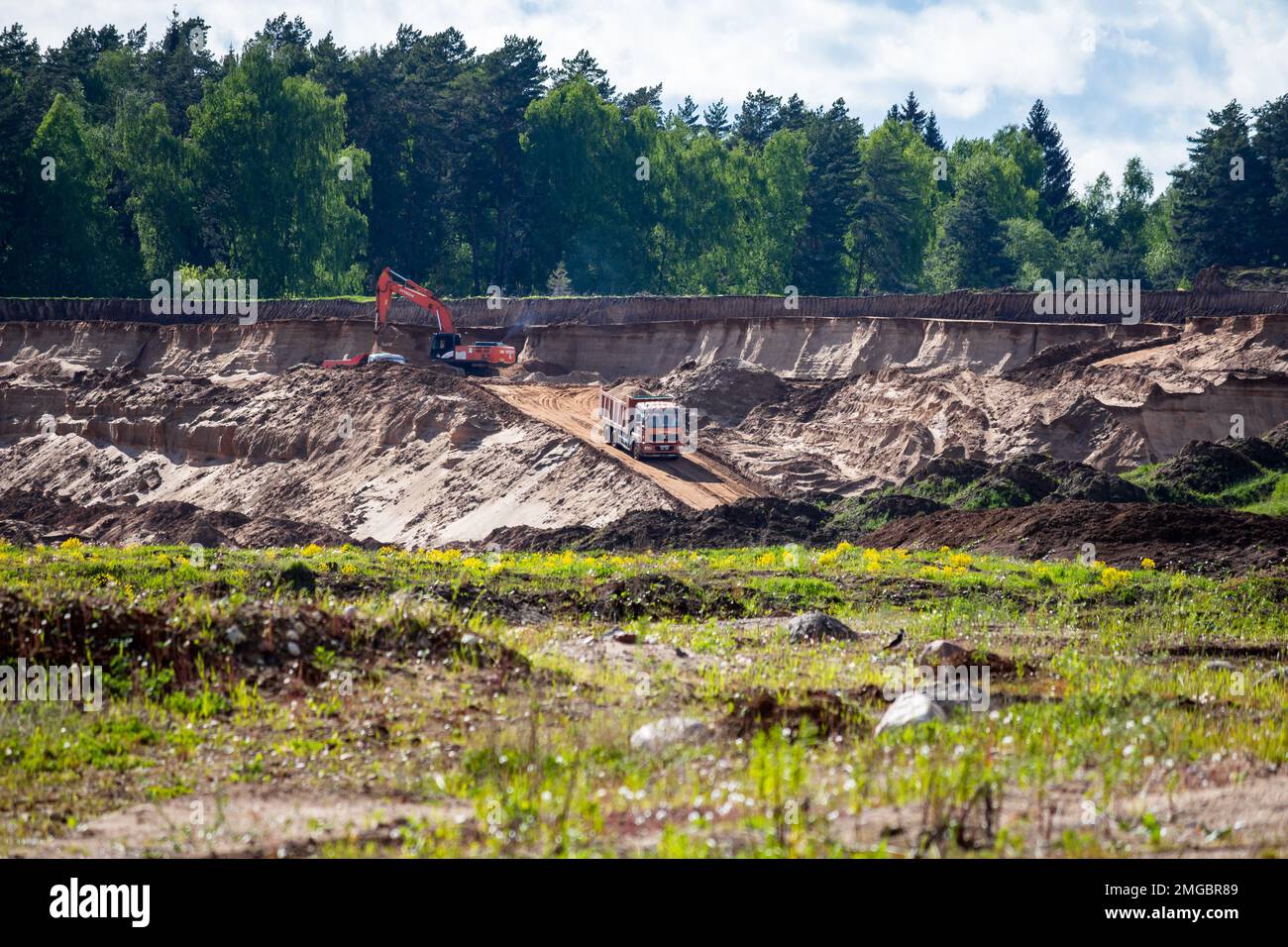 Mining in a quarry, transportation of sand by trucks in a sand pit ...