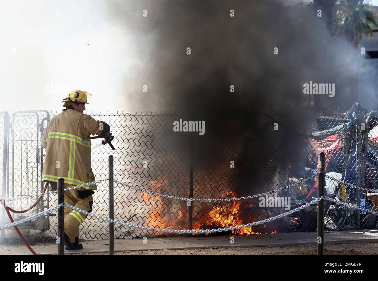 A Phoenix Fire Department firefighter begins to put out a fire inside a ...