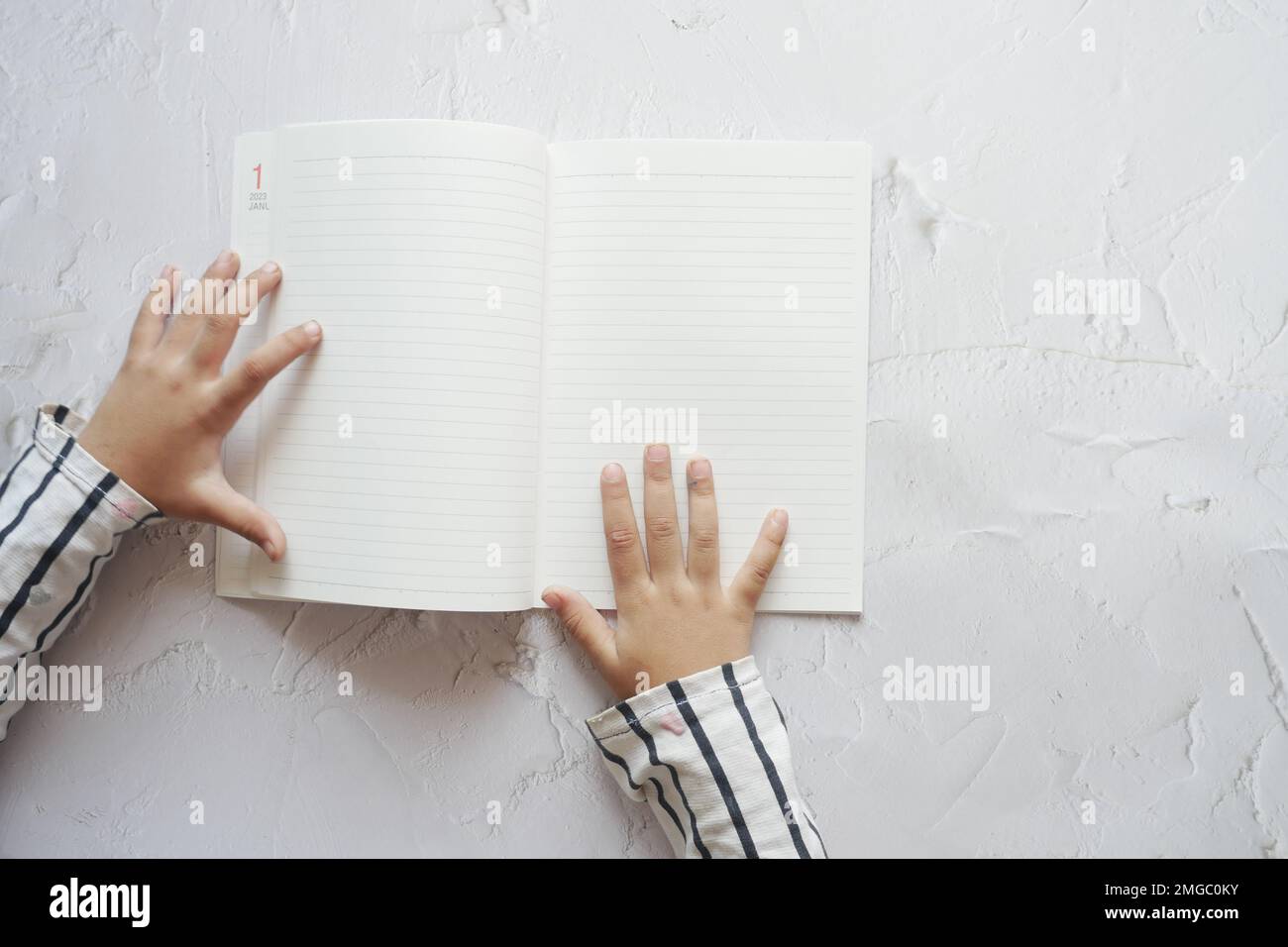 Child hand turning pager diary hi-res stock photography and images - Alamy
